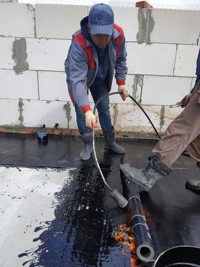 The Master Works with the Assistant To Work on the Waterproofing of the ...