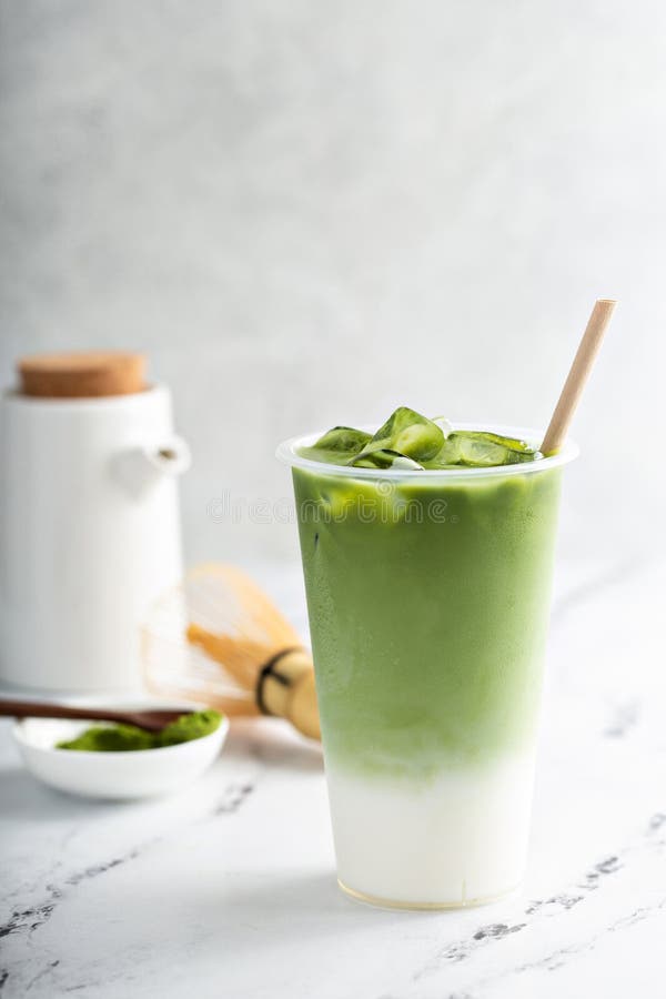 Matcha Iced Latte in a Tall Glass with Matcha Tea Over Milk Stock Photo ...