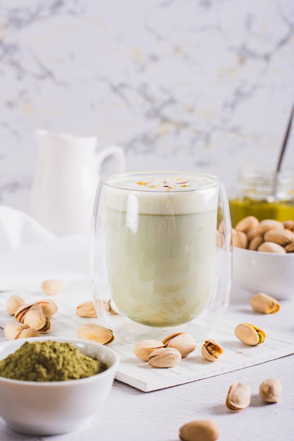 Matcha Tea with Pistachio Spread in a Glass and Nuts on the Table ...
