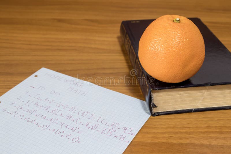 Math Homework with a Book and an Orange Fruit on a Wood Table Stock ...