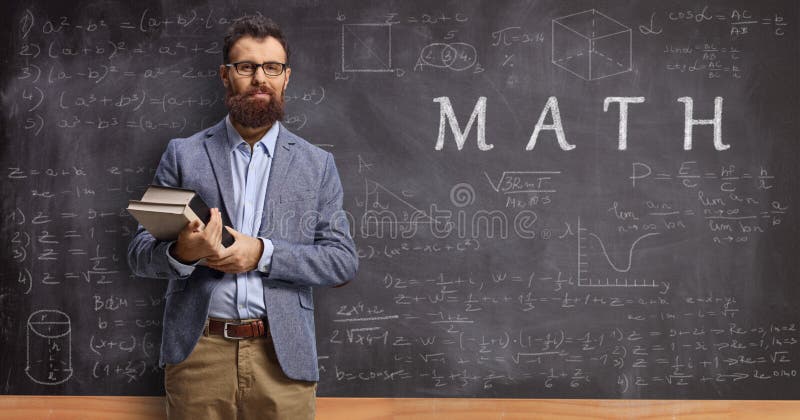Math Male Teacher Holding Books and Posing in Front of a Blackboard ...