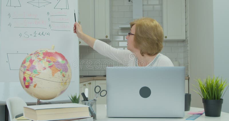 Math Teacher in Eyeglasses Having Video Chat with Students during ...
