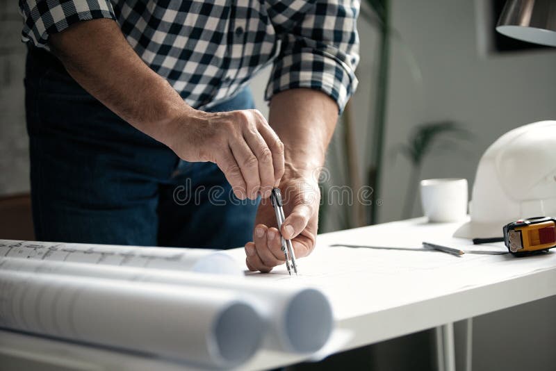 Mature Architect Working on Construction Blueprint in Modern Office ...