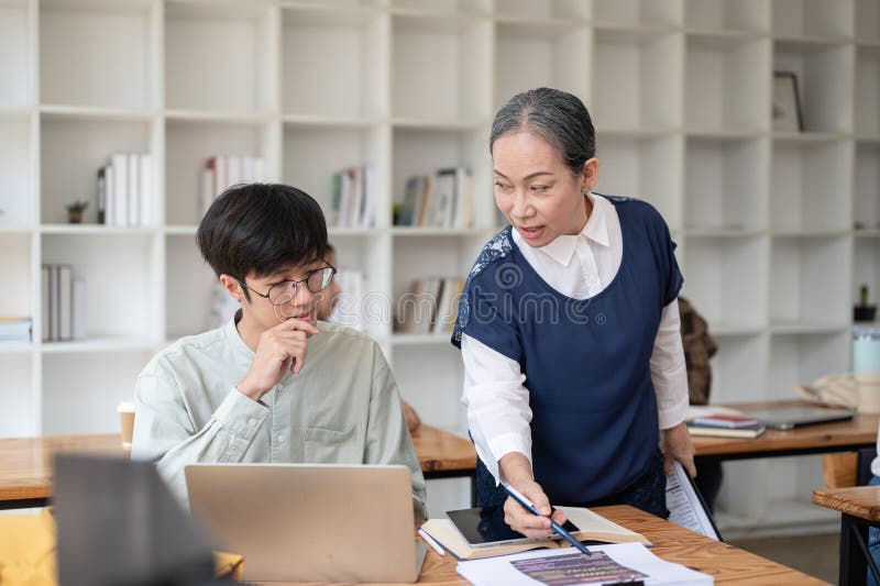 A Mature Asian Female Teacher Helping and Explaining Difficult Math ...
