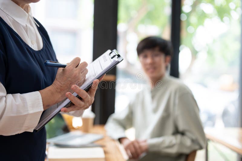 A Mature Asian Female Teacher Helping and Explaining Difficult Math ...