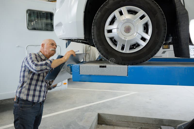 Mature Auto Mechanic Looking at Car Stock Photo - Image of security ...