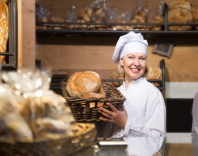 Mature Bakery Employee Offering Bread Stock Image - Image of cooking ...