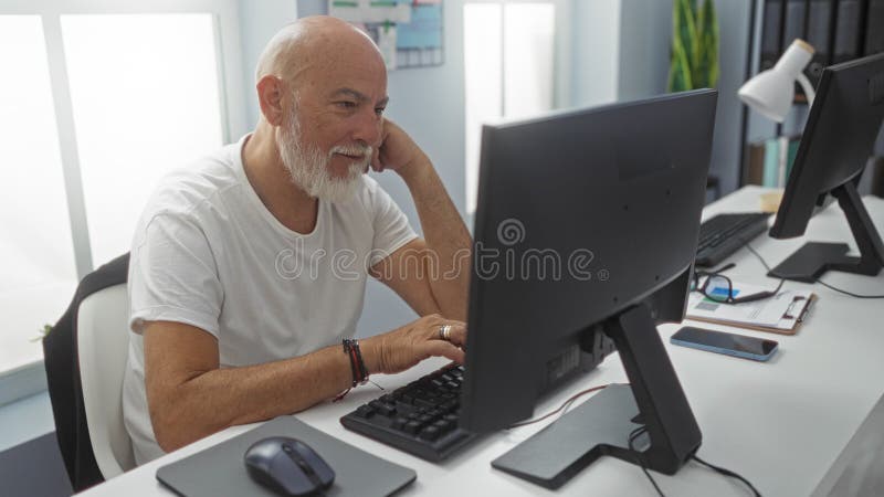 Mature Bald Man with a Beard Working on a Computer in a Modern Office ...