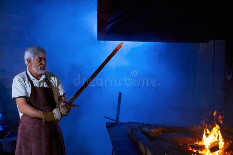 Making the Sword Out of Metal at the Forge. Blacksmith Pulls Out of the ...