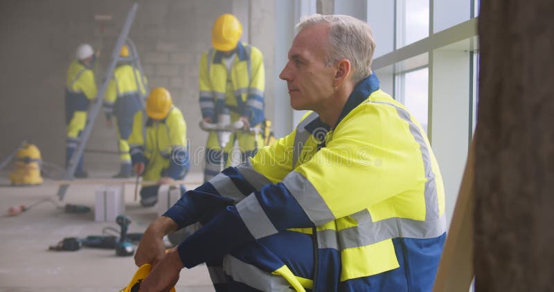 Mature Builder Standing and Looking Out of Window at Construction Site ...