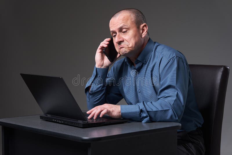 Mature Businessman Multitasking with Phone and Laptop Stock Photo ...