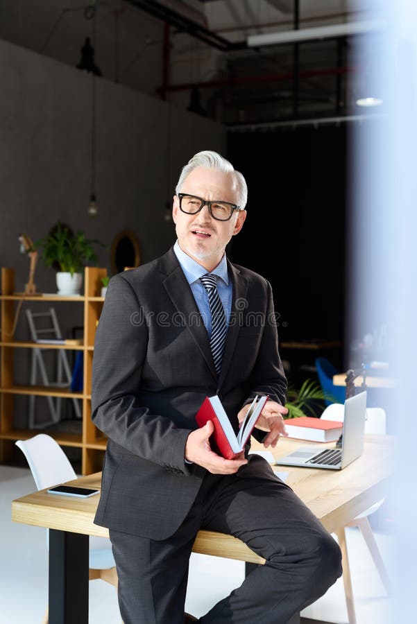 Mature Businessman Sitting on Table Stock Image - Image of people ...