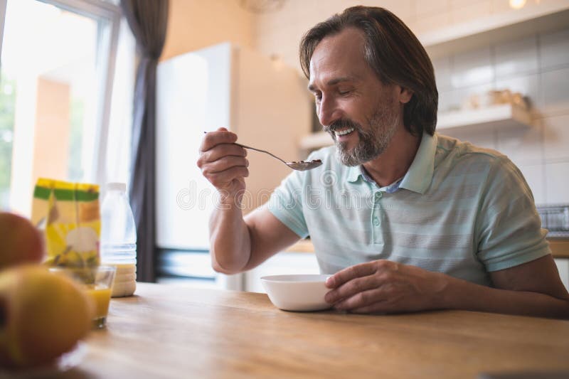 Mature Caucasian Man Sitting at the Table and Eating Breakfast Stock ...