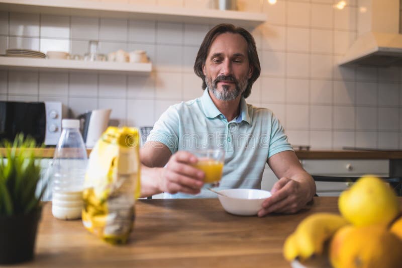Mature Caucasian Man Sitting at the Table and Eating Breakfast Stock ...
