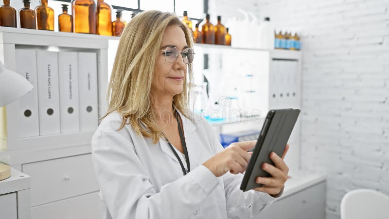 Mature Caucasian Woman in Lab Coat Using Digital Tablet in Modern ...