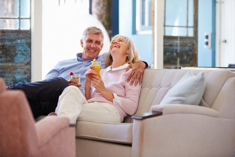 Mature Couple at Home Relaxing in Lounge with Cold Drinks Stock Image ...