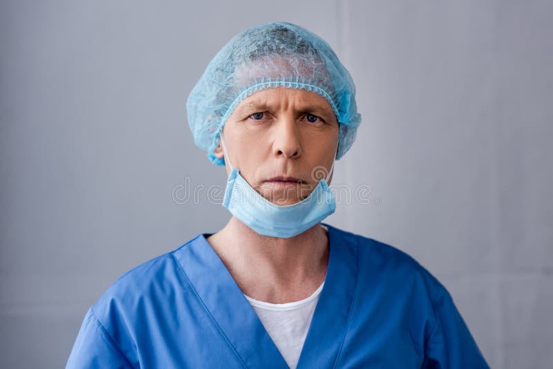Mature Doctor in Blue Medical Cap and Mask Looking at Camera Stock ...