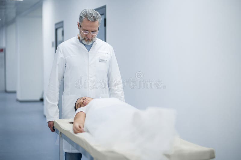 A Mature Doctor Carrying the Gurney with a Patient Stock Photo - Image ...
