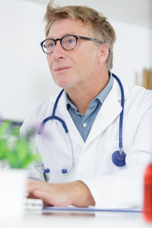 Mature doctor using pc stock photo. Image of medicative - 158693390