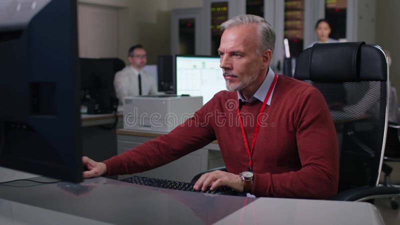 Mature Engineer Sit Down at Desk and Type on Computer in Modern Office ...