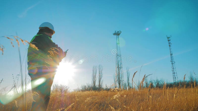 Mature Engineer Working on Smartphone with Satellite Dish Telecom ...
