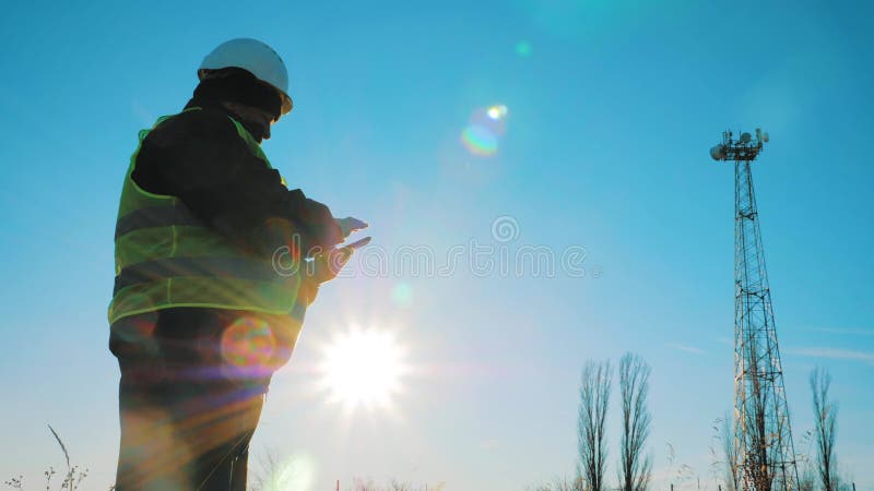 Mature Engineer Working on Smartphone with Satellite Dish Telecom ...