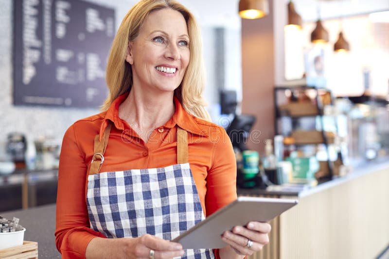 Mature Female Owner of Coffee Shop or Restaurant Using Digital Tablet ...