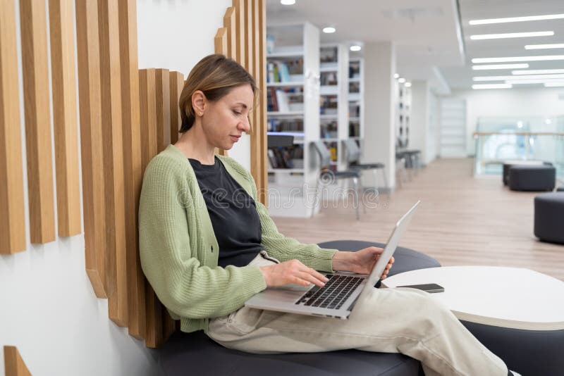Focused Woman Freelance Writer Working on Laptop in Library ...