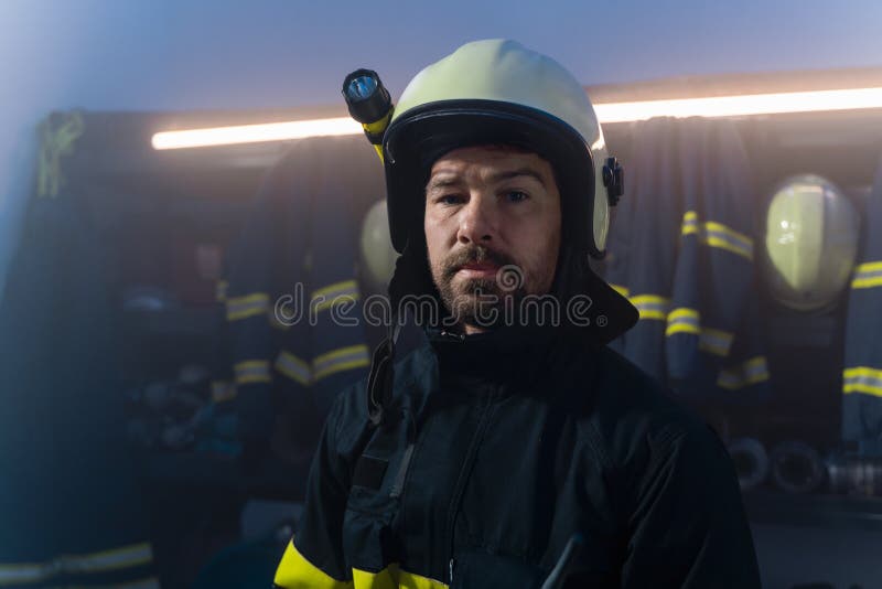 Mature Firefighter Preparing for Action in Fire Station at Night ...