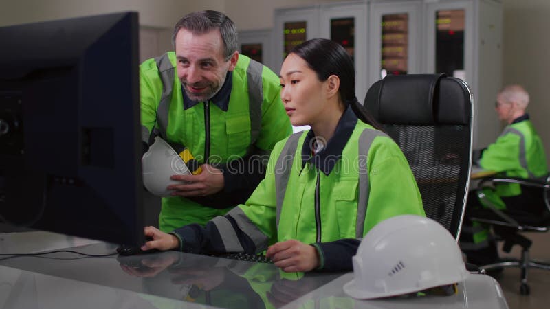 Mature Foreman in Uniform Help Young Asian Woman Engineer Working on ...