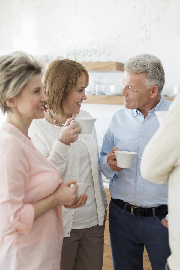 Mature Friends Talking while Holding Drinks at Home Stock Photo - Image ...