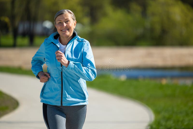 Mature Good-looking Woman Running in the Park and Looking Contented ...