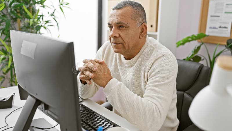 Mature Hispanic Man in Thoughtful Pose at Office Workplace Staring at ...