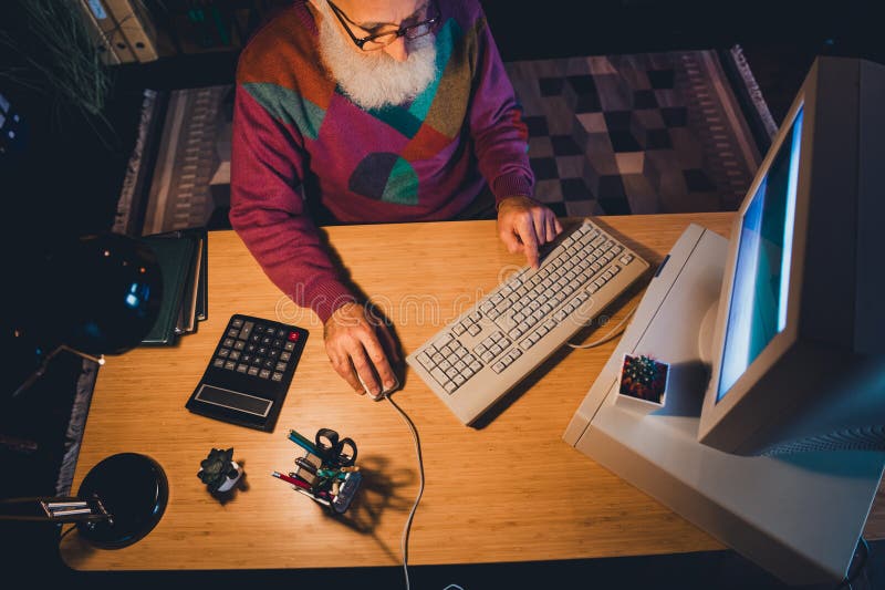 Mature Individual Working at a Computer Desk in a Cozy Environment ...