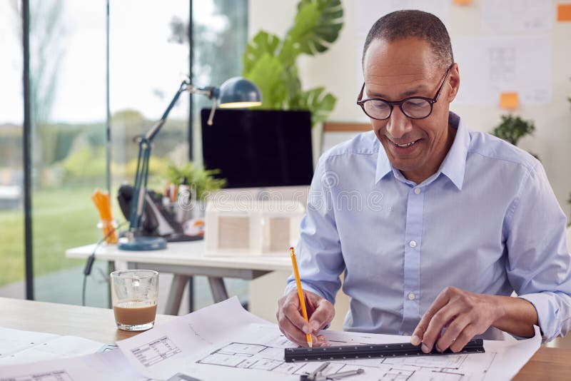 Mature Male Architect Working in Office on Plans for New Building Stock ... Mature Male Architect Working in Office on Plans for New Building Stock ...