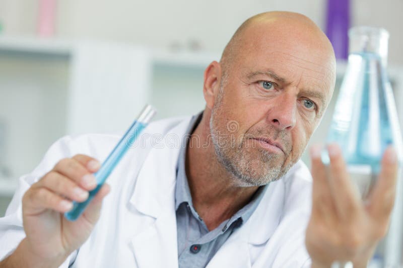 Mature Male Scientist Examining Liquid in Erlenmeyer Flask Stock Photo ...