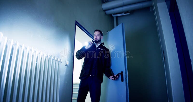 Mature Male Security Guard with Flashlight Standing in Corridor Stock ...
