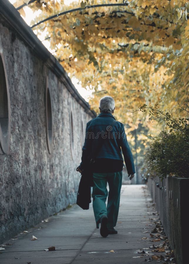 Mature Man Casually Walking Down a City Sidewalk Stock Image - Image of ...