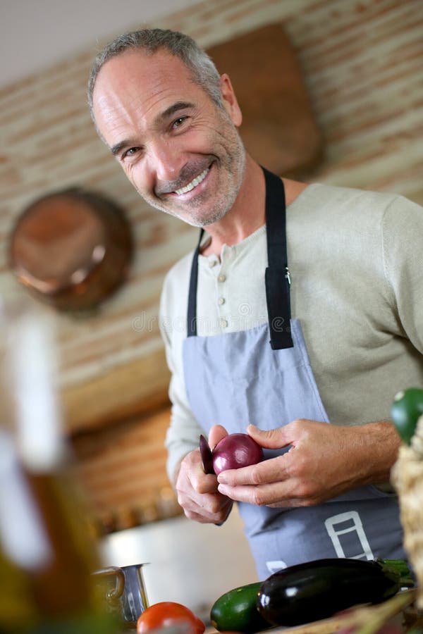 Mature man cooking at home stock photo. Image of kitchen - 33917340