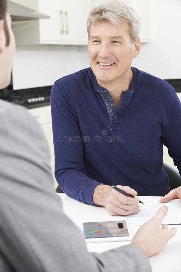 Mature Man with Financial Advisor Signing Document at Home Stock Image ...