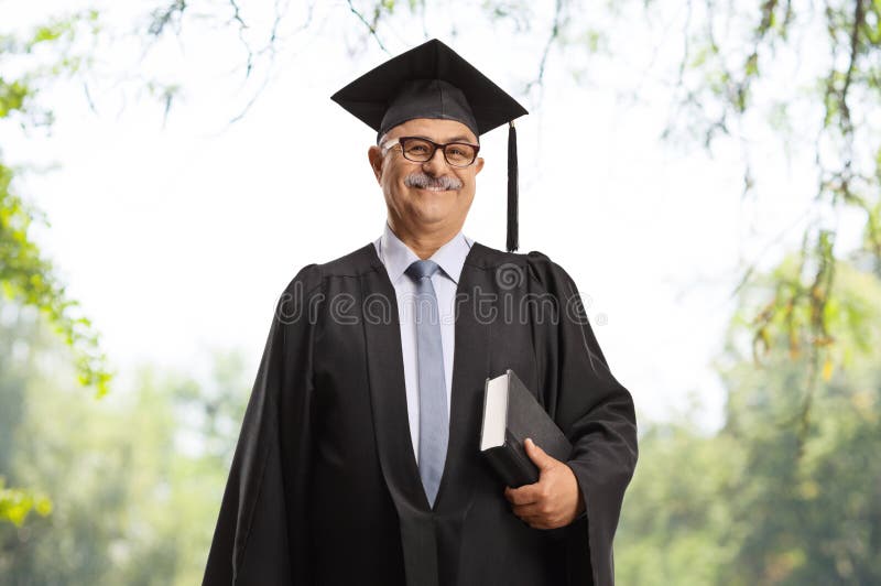 Mature Man in a Graduation Gown Holding a Book Stock Image - Image of ...