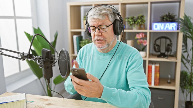 Mature Man with Headphones Using Smartphone in a Home Radio Studio ...