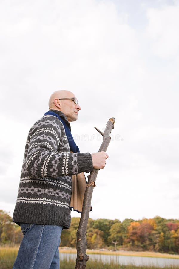 Mature man holding a stick stock photo. Image of retired - 62534494