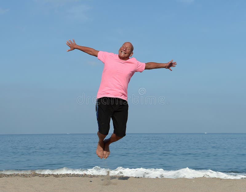 Mature Man Jumping on Beach Stock Image - Image of shore, sunny: 72237595