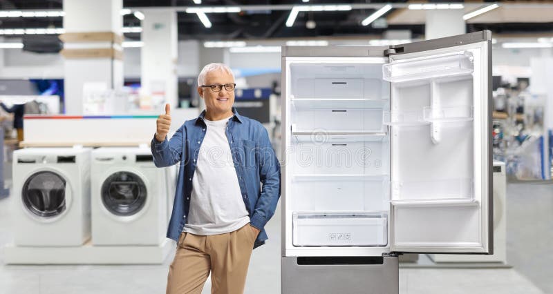 Mature Man Leaning on a Fridge in a Store Stock Photo - Image of ...