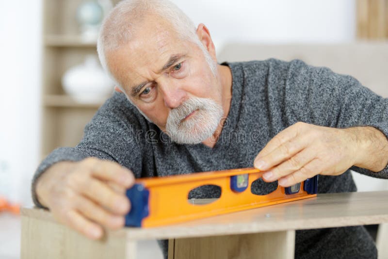 Mature Man Leveling Furniture Stock Photo - Image of improvement ...