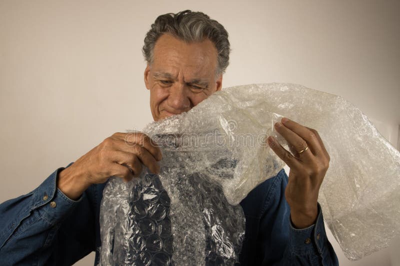 Mature Man Looking Over Some Bubble Wrap Stock Photo - Image of looking ...