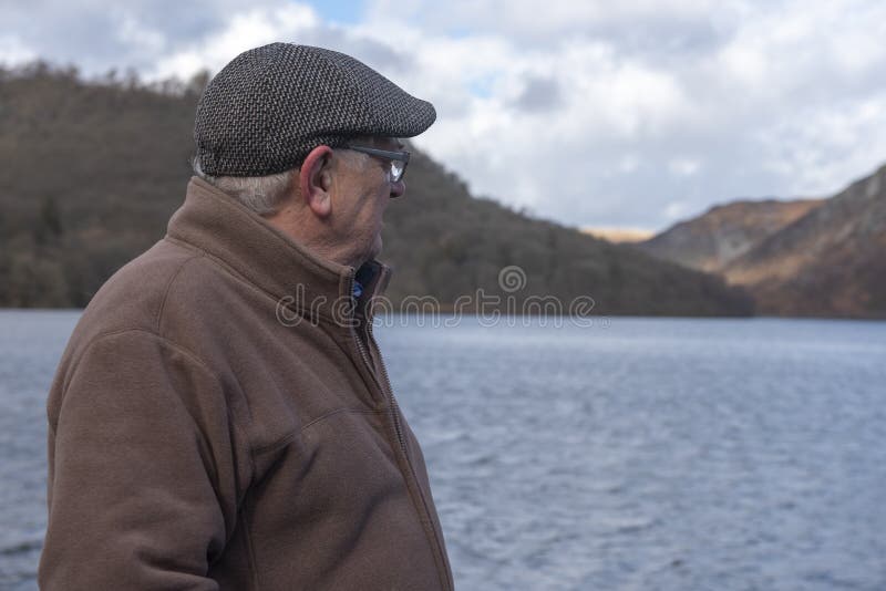 Senior Man Sitting On A Wooden Bench, Overlooking A Lake Stock Photo ...