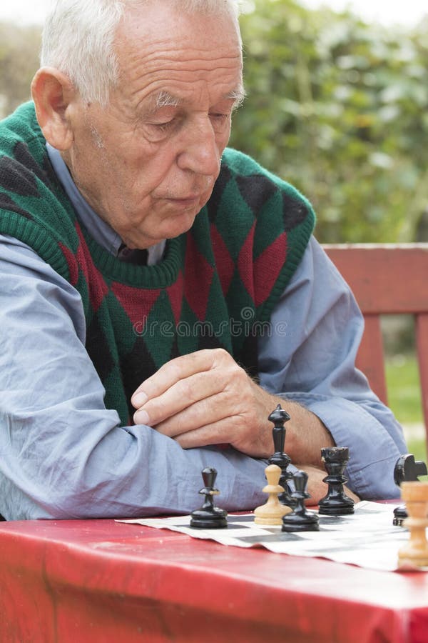 Mature man playing chess stock photo. Image of clock - 78605014