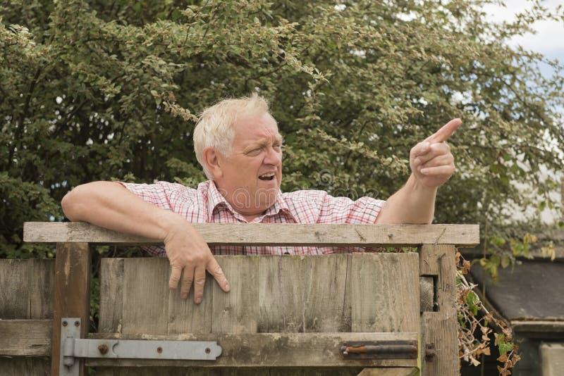 Mature Man Shouting Over a Fence in the Garden Stock Photo - Image of ...
